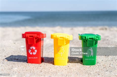 종이 플라스틱 유리 및 바다 전망과 모래 해변에서 재활용에 적합한 유기 폐기물이있는 다양한 색깔의 쓰레기통 쓰레기 분리 쓰레기 선별 0명에 대한 스톡 사진 및 기타 이미지