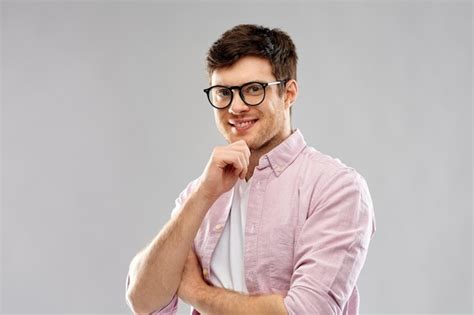 Premium Photo Smiling Young Man In Glasses Over Grey Background