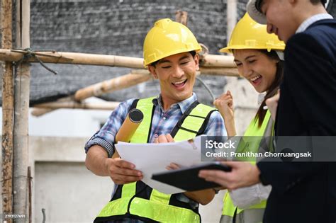 수석 엔지니어 또는 건축가 및 작업자는 성공적인 프로젝트 이정표를 축하하고 흥분 팀워크 및 건설 프로젝트의 성과를 가지고 태블릿에서 계획 및 문서를 검토합니다