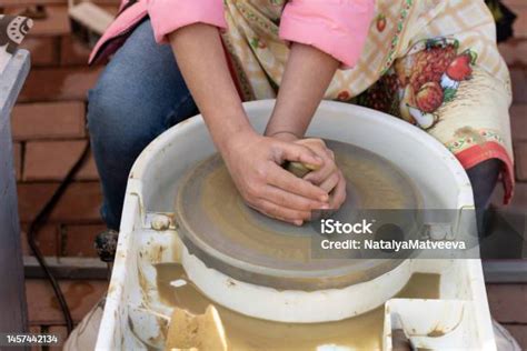 도자기 수업에서 항아리 만들기 11월 건물 그늘에서 야외에서 도자기 작업장에서 점토로 세라믹 냄비를 만드는 도공 바퀴에서 일하는 여성 도예가 아이에 대한 스톡 사진 및 기타