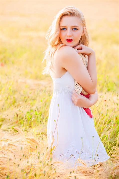 Belle Jeune Fille Blonde Seule Dans La Robe Blanche Avec Le Chapeau De Paille Image Stock