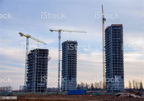 푸른 하늘을 배경으로 건설 현장에서 일하는 타워크레인 콘크리트 양동이를 들어 올리는 크레인 새로운 주거 용 건물의 건설 과정 시멘트 혼합물의 운송 블록 및 붓기 개발에 대한