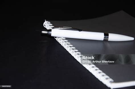 메모에 대한 회색 노트북과 검은 색 배경에 흰색 펜 닫혀 있고 열린 확장 된 상태의 메모장입니다 아이디어 계획 작업을 작성하기