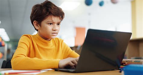 소년 어린이 및 전자 학습 온라인 교육 또는 학교 도서관 탐색을 위해 노트북으로 타이핑합니다 학습자 학생 또는 어린이가 초등 프로젝트 학술 연구 또는 아동 발달을 위해