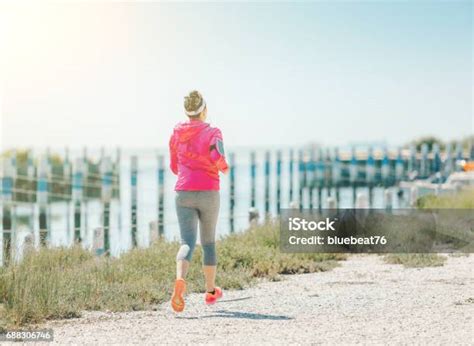 건강 한 여성 러너 바다 근처 조깅입니다 휘트니스 여자 운동 분홍색 운동복과 신발에서 실행 되는 액티브 라이프 스타일 훈련 심장 생활 개인 장식품에 대한 스톡 사진 및 기타