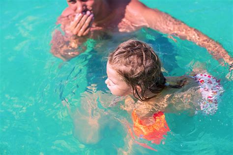 뜨거운 여름 날에 풍선 반지와 야외 수영장에서 그녀의 아빠와 함께 재생 하는 작은 소녀 아이 들 수영 배워야 아이 수의 장난감 어린이 열 대 휴양지에서 재생합니다 가족 해변