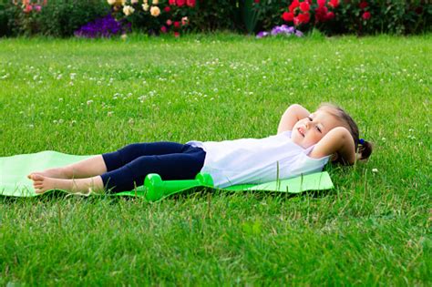 흰색 티셔츠를 입은 어린 귀여운 소녀 13은 꽃의 배경에 잔디에 녹색 매트에 스포츠에 간다 T 셔츠에 대한 스톡 사진 및 기타