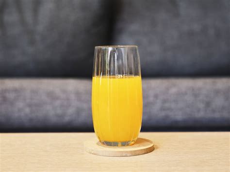 테이블에 앉아있는 오렌지 주스 한 잔 사진 Unsplash의 무료 마시다 이미지