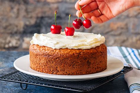 수 제 크림 치즈 설탕 프로 스 팅 신선 하 고 잘 익은 체리와 사 우 어 크림 케이크를 장식 하는 여자 0명에 대한 스톡 사진