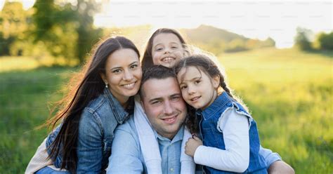 봄 자연 속에서 야외에 앉아 카메라를 바라보는 두 명의 작은 딸과 함께 행복한 가족의 전면 모습 사진 Unsplash의 아름다움 이미지