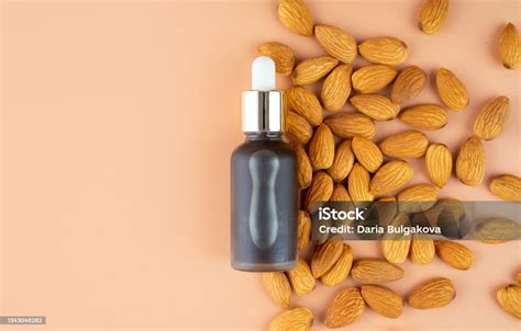 크리에이티브 레이아웃 매트 한 유리 병에 천연 아몬드 오일과 파스텔 베이지 색 배경에 아몬드의 산란 스킨 케어 뷰티 및 건강의 개념 상단 보기 복사 공간 Almond Oil