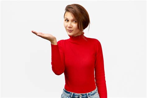 놀란 젊은 유럽 여자 세련 된 빨간 스웨터를 입고 손바닥을 제기 뭔가를 들고 척 충격 표정으로 외모 스튜디오에서 스탠드 겁먹은에 대한 스톡 사진 및 기타 이미지 Istock