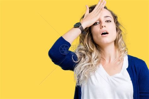美丽的年轻金发女郎在与世隔绝的背景下惊讶地用手捂着头因为错误高清图片下载 正版图片504154702 摄图网