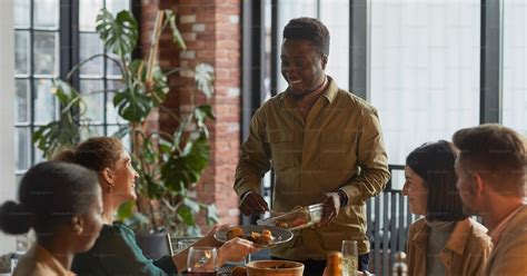 집에서 친구 및 가족과 함께 저녁 파티를 주최하면서 음식을 제공하는 아프리카계 미국인 남성의 초상화 복사 공간 사진 Unsplash의 우정 이미지