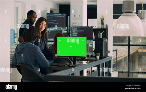 Team Of Programmers Working On Source Code With Greenscreen Monitor In