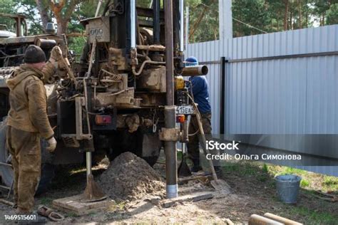 차에 드릴링 리그를 가진 노동자의 팀은 지상에 있는 물을 위한 지하수 우물을 뚫고 있습니다 금속 케이싱 파이프를 땅에 삽입 개별 식수 공급 장치 설치 2022년 6월 28일
