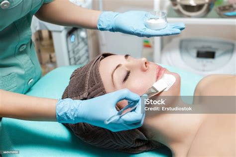 미용사는 스파 살롱에서 아름 다운 젊은 여자에 얼굴 마스크를 적용 합니다 미용 절차 스킨 케어 미세 박피 술 가꿔주기에 대한