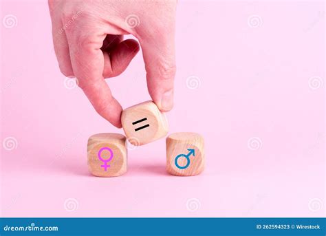 Wooden Cubes Showing The Equality Between Two Genders On A Pink