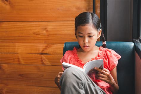 귀여운 어린 아시아 소녀는 집에서 거실에서 책을 읽고 교육과 지식 개념 10 11세에 대한 스톡 사진 및 기타 이미지 10 11세 가정 생활 개념 Istock
