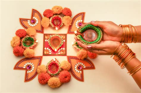 흰색 배경에 메리 골드 꽃으로 장식 된 전통적인 랑골과 여성 손 조명 점토 램프 디 왈리 배경 콘텐츠 디왈리에 대한 스톡 사진 및 기타 이미지 Istock