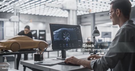 자동차 디자이너 겸 모델러는 스튜디오에서 미래형 자동차를 만드는 팀으로 일하고 있습니다 데스크톱 컴퓨터에서 디지털 렌더링 작업을