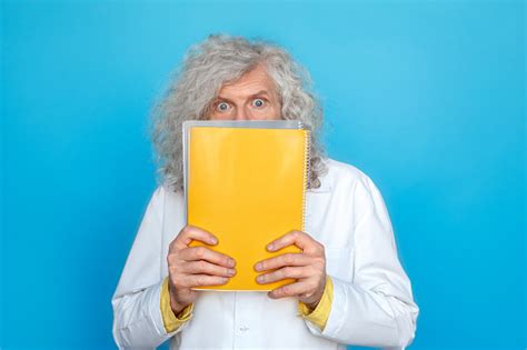 노인 을 입고 의사의 가운 스튜디오 고립 에 푸른 서 얼굴 과 책 찾고 카메라 충격 남성에 대한 스톡 사진 및 기타 이미지 남성 노인 곱슬 머리 Istock