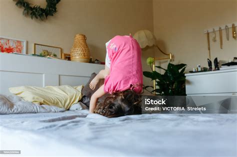 분홍색 잠옷을 입은 어린 아이가 침대에서 공중제비를 하고 있다 4 5세에 대한 스톡 사진 및 기타 이미지 4 5세 가정 생활 갈색 머리 Istock