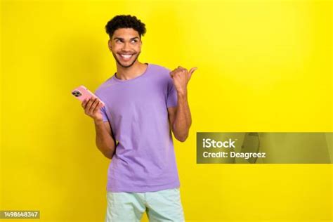 잘 생긴 블로거 남자의 사진은 스마트 폰을 들고 노란색 배경에 격리 된 손가락 빈 공간을 나타냅니다 전화에 대한 스톡 사진 및 기타 이미지 Istock