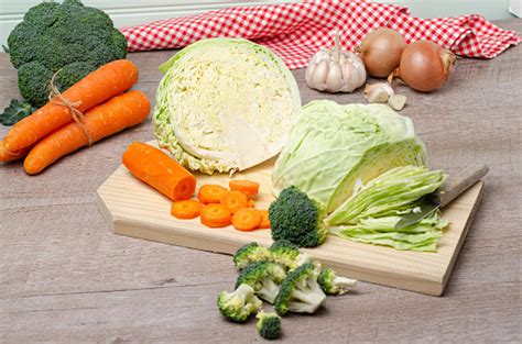 나무 도마에 신선한 녹색 브로콜리 당근 마늘 양파와 양배추 매크로 사진 녹색 신선한 야채 브로콜리 식이 요법과 건강한 식사를위한 녹색 야채 유기농 식품 준비 농업에 대한