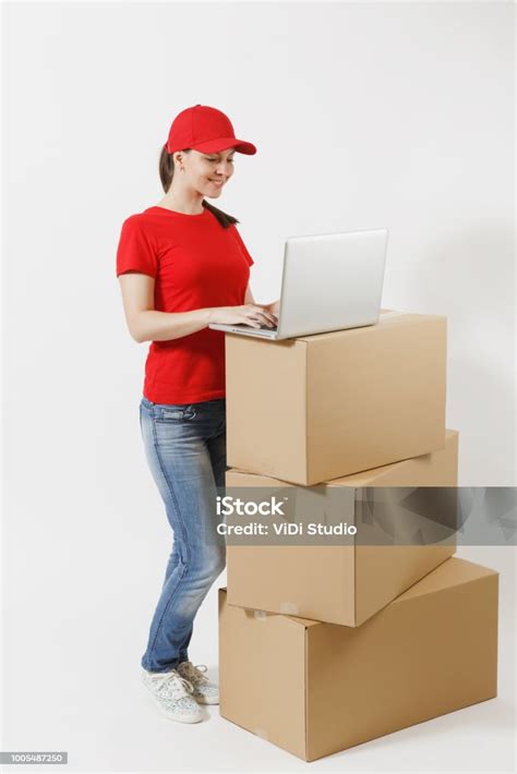 전체 길이 빨간 모자에 배달 젊은 여자의 초상화 T셔츠는 흰색 배경에 고립 여성 택배 노트북 Pc 컴퓨터와 빈 골 판지 상자