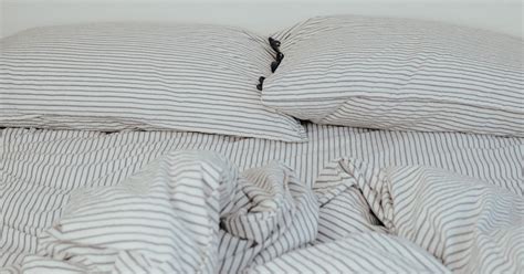 줄무늬 이불과 베개가 있는 정돈되지 않은 침대 사진 Unsplash의 지저분한 침대 이미지