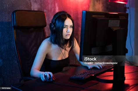 Mmorpg 나 그녀의 컴퓨터에 전략 비디오 게임 전문 여자 게이머 놀이 그녀 또는 인터넷 카페에서 온라인 사이버 게임 대회 가정에서 놀이에 참여 하는 게이밍 헤드셋을 착용