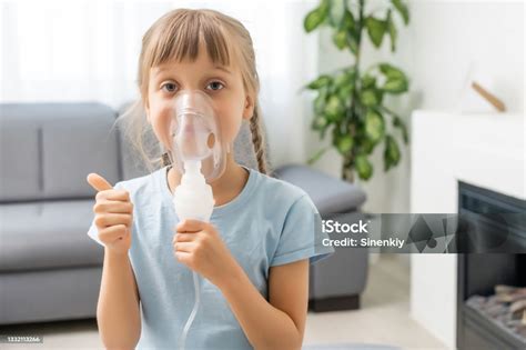 아이 소녀는 분무기로 흡입을합니다 흡입기를 손에 들고 집에서 흡입기를 통해 호흡하는 아픈 아이 건강관리와 의술에 대한 스톡 사진 및 기타 이미지 Istock