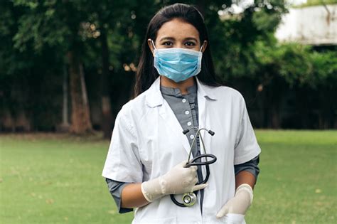흰색 코트 의료 마스크 및 청진기를 착용한 자신감 있는 인도 여성 의사의 초상화 인도 여성의 성공 개념 보호 마스크에 대한 스톡 사진 및 기타 이미지 Istock