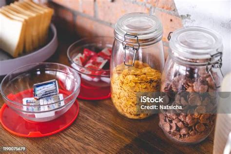 선명한 옥수수와 초콜릿 시리얼 투명 유리 용기 병에 아침 식사 에 대한 준비 빈티지 붉은 벽돌 벽에 대한 나무 테이블에 배치 아침 음식 0명에 대한 스톡 사진 및 기타
