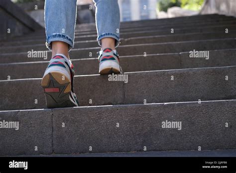 Woman Wearing Jeans And Sneakers Going Up Steep Stairs Stock Photo Alamy