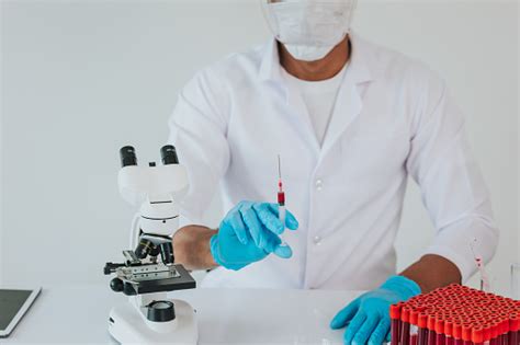 의사가 실험실에 있는 분석기가 있는 선반에서 혈액 샘플 튜브를 꺼냅니다 연구실에서 혈액 검사관을 들고 있는 기술자 Dna에 대한 스톡 사진 및 기타 이미지 Istock