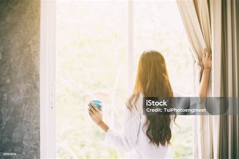 아시아 커피를 마시고 완전히 그녀의 침대에서 깨어난 휴식 성과 햇빛에 신선한 공기를 얻기 위하여 아침에 커튼을 열고 가정 생활에 대한 스톡 사진 및 기타 이미지 Istock