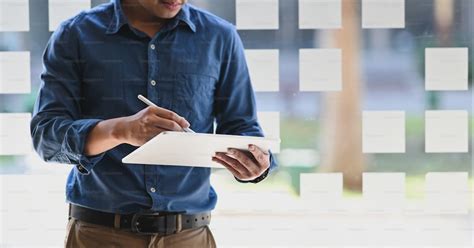 사무실에 서 있는 동안 컴퓨터 태블릿과 스타일러스 펜을 사용들고 있는 남자 사진 Unsplash의 태국 이미지