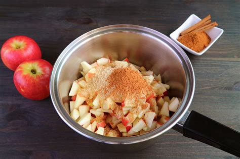 사과 설탕에 절인 과일을 만들기 위해 깍둑썰기한 사과 냄비에 계피 가루와 정제되지 않은 설탕을 넣습니다 0명에 대한 스톡 사진 및 기타 이미지 Istock