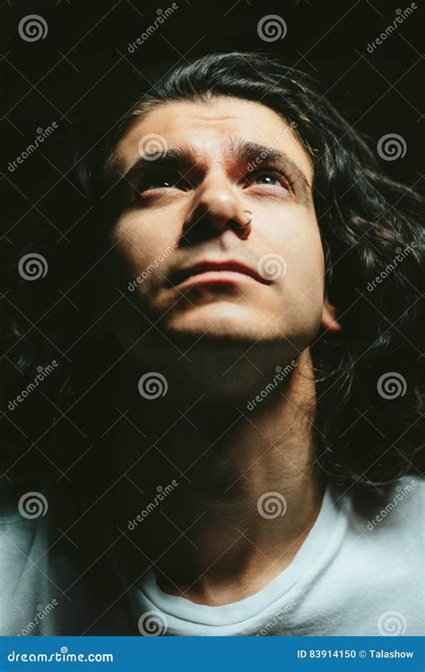 Het Portret Van Een Knappe Jonge Mens Met Lang Haar Ziet Omhoog Eruit Stock Foto Image Of