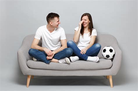 흰색 티셔츠에 웃 고 커플 여자 남자 축구 팬 응원 스튜디오에서 회색 배경에 고립 된 축구 공을 좋아하는 팀 지원 사람들의 감정 스포츠 가족 레저 라이프 스타일 개념입니다