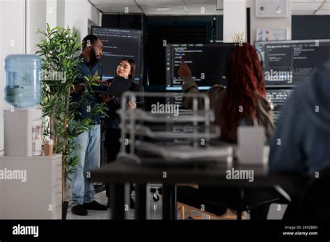 Engineers Checking Artificial Intelligence Code Looking For Errors On Laptop Checking Big Tv