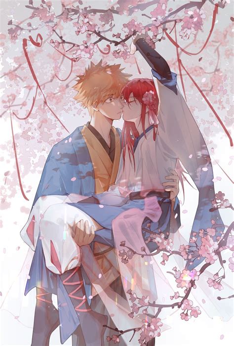 Two People Are Hugging Under A Tree With Pink Flowers On It And One Is Holding The Other