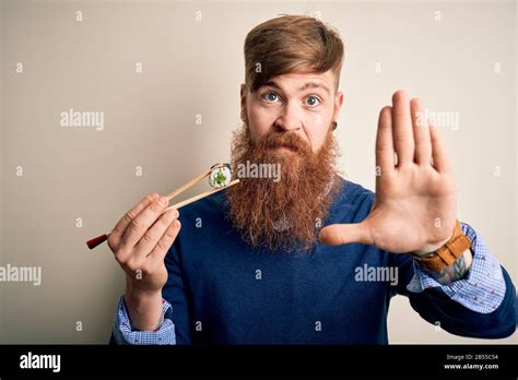 Redhead Irish Man With Beard Eating Green Maki Sushi Using Chopsticks