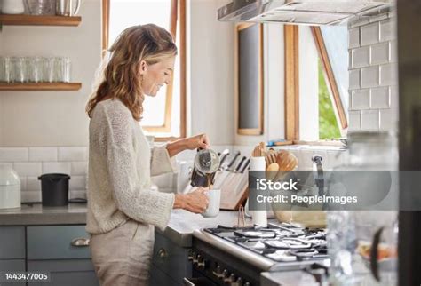 성숙한 여자는 부엌에서 커피를 마시고 아침 식사를 하고 호주의 집에서 아침을 쉬기 시작합니다 아파트 하우스에서 강하고 뜨겁고 검은 에스프레소 차 기쁨을 즐기는 행복한 아가씨