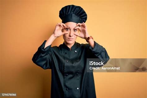 젊은 아름다운 요리사 여자 밥솥 유니폼과 모자를 입고 노란색 배경 위에 서손가락으로 눈을 뜨고 졸리고 아침 피로에 대한 피곤 개념에 대한 스톡 사진 및 기타 이미지 Istock