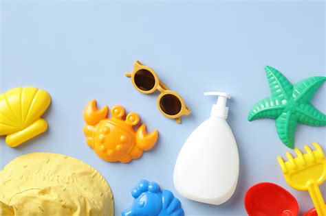 파나마 모자 선글라스 파란색 배경에 모래 곰팡이가있는 아기 태양 보호 크림 모형 선 스크린 로션 병 디자인 브랜딩 0명에 대한