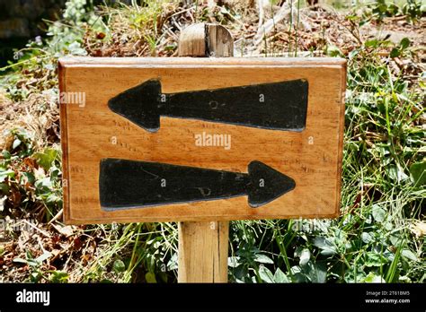 Brown Wooden Sign With Arrows Pointing In Opposite Directions Stock Photo Alamy