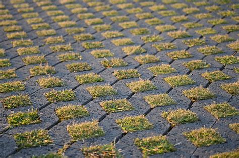 회색 자연석으로 만든 사각형 타일의 배경 질감입니다 도로의 콘크리트 가로 기하학적 포장 패턴 녹색 잔디 및 생태 주차장 녹색 주차 지속 가능한 개발 도시 0명에 대한 스톡